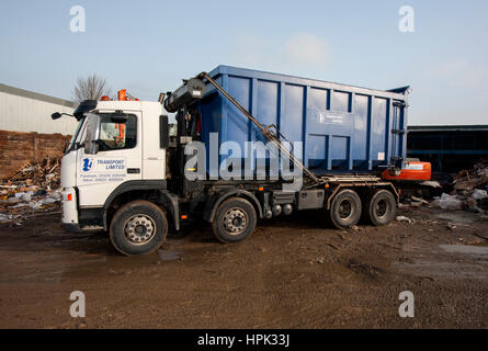 A large skip dumpster truck lorry unloading waste at a recycling centre ...