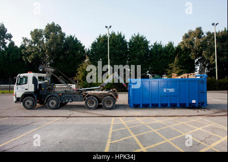 A large skip dumpster truck lorry unloading waste at a recycling centre ...