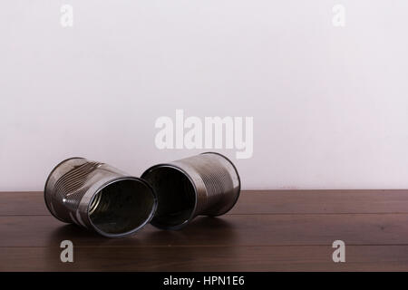 Battered tin cans on a rustic wooden background Stock Photo - Alamy