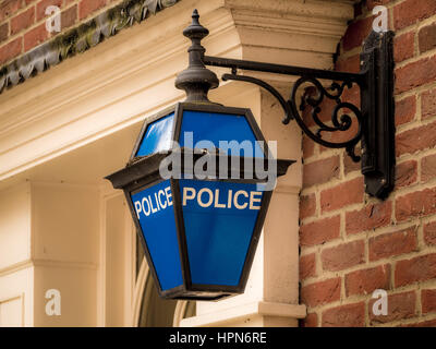 Old fashioned vintage police sign on a globe light hangs on a brick ...