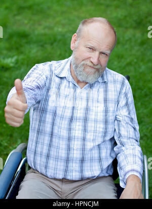 senior man with parkinson disease sitting on couch in knitted cardigan ...