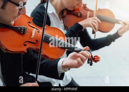 Two violinists performing together hands close up, classical music ...