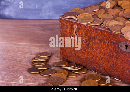 Old wooden chest filled with old copper coins Stock Photo - Alamy