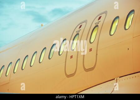 Windows of airplane with emergency exit door Stock Photo - Alamy