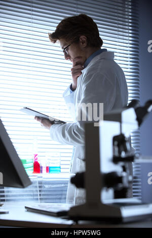 Researcher reading medical records in the chemical laboratory with ...