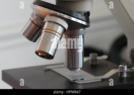 high power objective lens and microscope slide on microscope stage ...