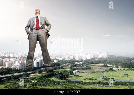 Giant businessman with long legs looking away Stock Photo - Alamy