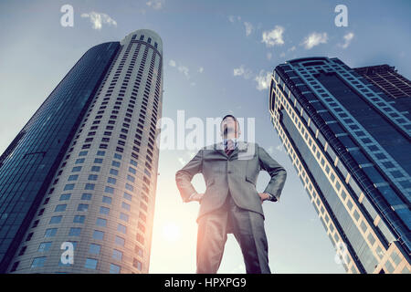 Giant businessman with long legs looking away Stock Photo - Alamy