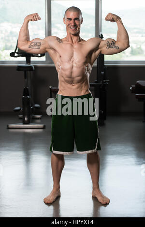 Male bodybuilder posing, showing front body muscles, studio shot on ...