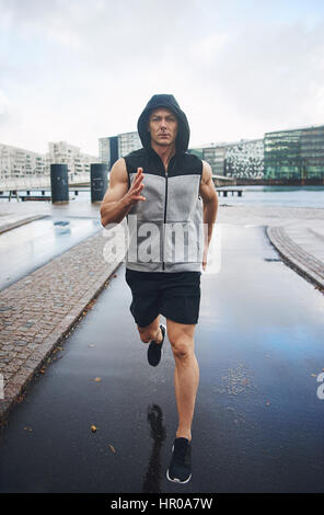 energetic athletic muscular man runner running outdoor on green grass ...