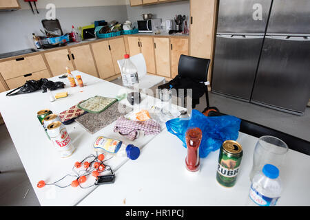 Dirty messy student shared kitchen with piles of washing up by the sink ...