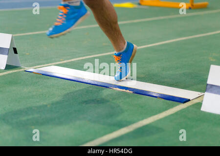 Sportsman landing his leg on board before taking off in long jump or ...