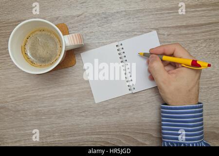 Male hand writing plans in a notepad Stock Photo - Alamy