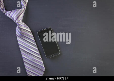 Men's tie with smart phone on a wood background Stock Photo - Alamy