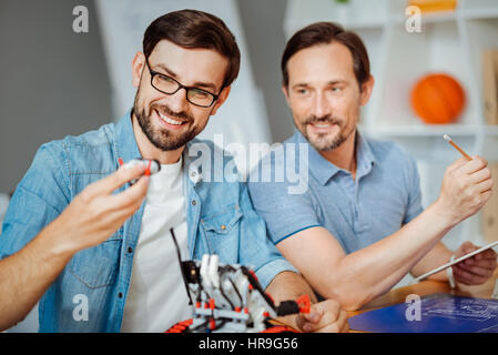 Positive engineers testing the robot Stock Photo - Alamy