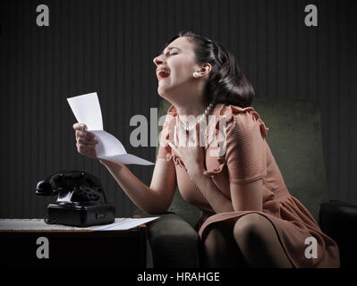 Young woman reading a letter crying desperate Stock Photo - Alamy