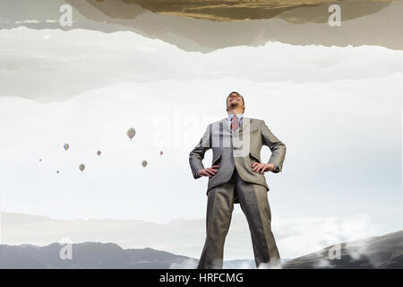 Giant businessman with long legs looking away Stock Photo - Alamy