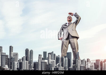 Giant businessman with long legs looking away Stock Photo - Alamy