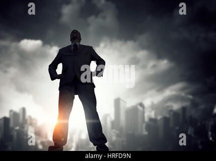 Giant businessman with long legs looking away Stock Photo - Alamy
