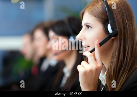 Call center. Group of operators at work. Focus on young brunette woman. Business concept Stock ...