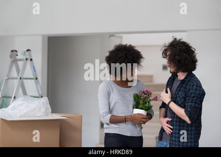 Happy young multiethnic couple unpacking or packing boxes and moving ...