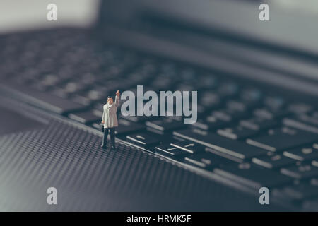 Miniature businessman waving on top of the laptop. Business concept ...