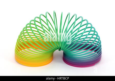 Slinky - a rainbow colored plastic toy spring, isolated on light ...