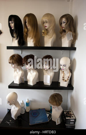 Wigs on display with female hair pieces and extensions in a shopping ...