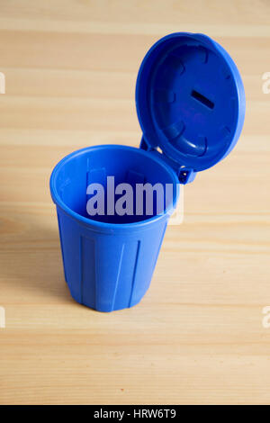 a blue garbage can on wooden background Stock Photo - Alamy