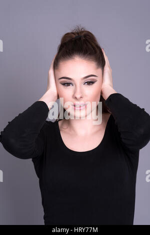 Woman holding hands over ears Stock Photo - Alamy