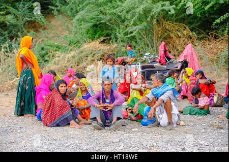 A group of Rajasthani people from the Bhil Tribe sit and stand around ...