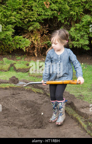 young girl digging a hole in the sand Stock Photo - Alamy