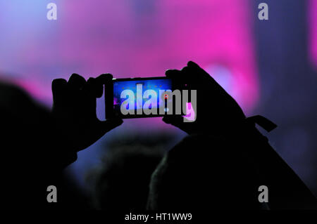 Crowd of partying people taking photos with smartphone at Electric ...