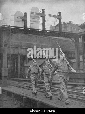 1940 Wartime army man, an Armed railway guard wearing coat, and tin ...