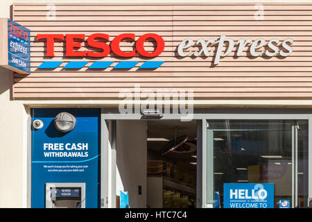 Tesco Express store, shop front exterior entrance, at dusk at Greenwich ...