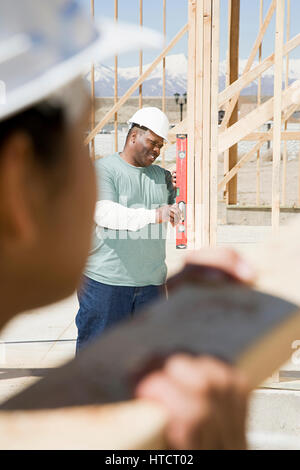 An experienced man using a spirit level and welds a seam on a spiral ...