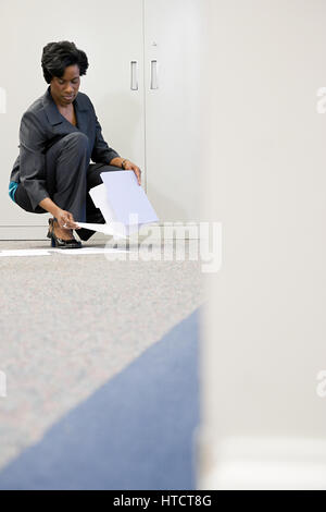 Woman picking up dropped paper Stock Photo - Alamy