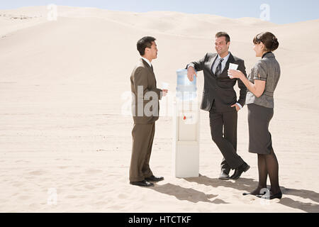 People around water cooler in the desert Stock Photo - Alamy