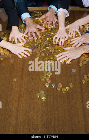 Greed for money. Hands grabbing coins Stock Photo - Alamy