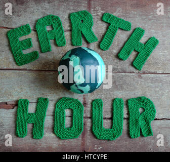 Earth hour letter in green yarn on wood background, a symbol for save ...