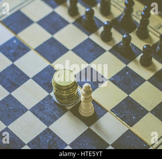 Picture of a chess board with stack of coins as the king Stock Photo ...