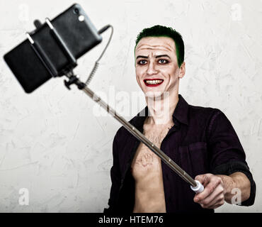 Scary halloween clown with menacing smile holding sack dark room with ...