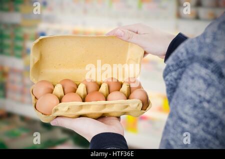 A male hand holding an egg with an egg carton on the tab Stock Photo ...