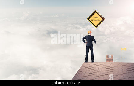 Man holding safety sign indicating under construction notice. Mixed ...
