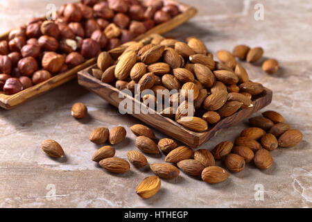 Almonds in old wooden dish on a kitchen table Stock Photo - Alamy