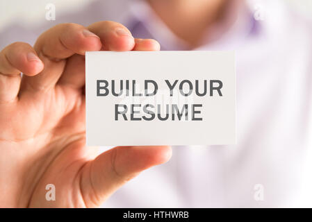 businessman holding a card with text RESUME Stock Photo - Alamy