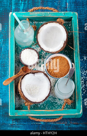Coconut with coconut oil, water and sugar and coconut flakes on a ...
