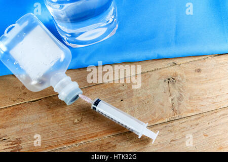 saline solution and injection needle on wood table Stock Photo - Alamy