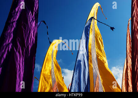 Brightly coloured banner flags flapping against blue sunny sky Stock ...