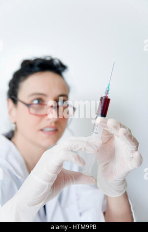 Young woman in scientific lab with pipette and chemicals in test tubes ...